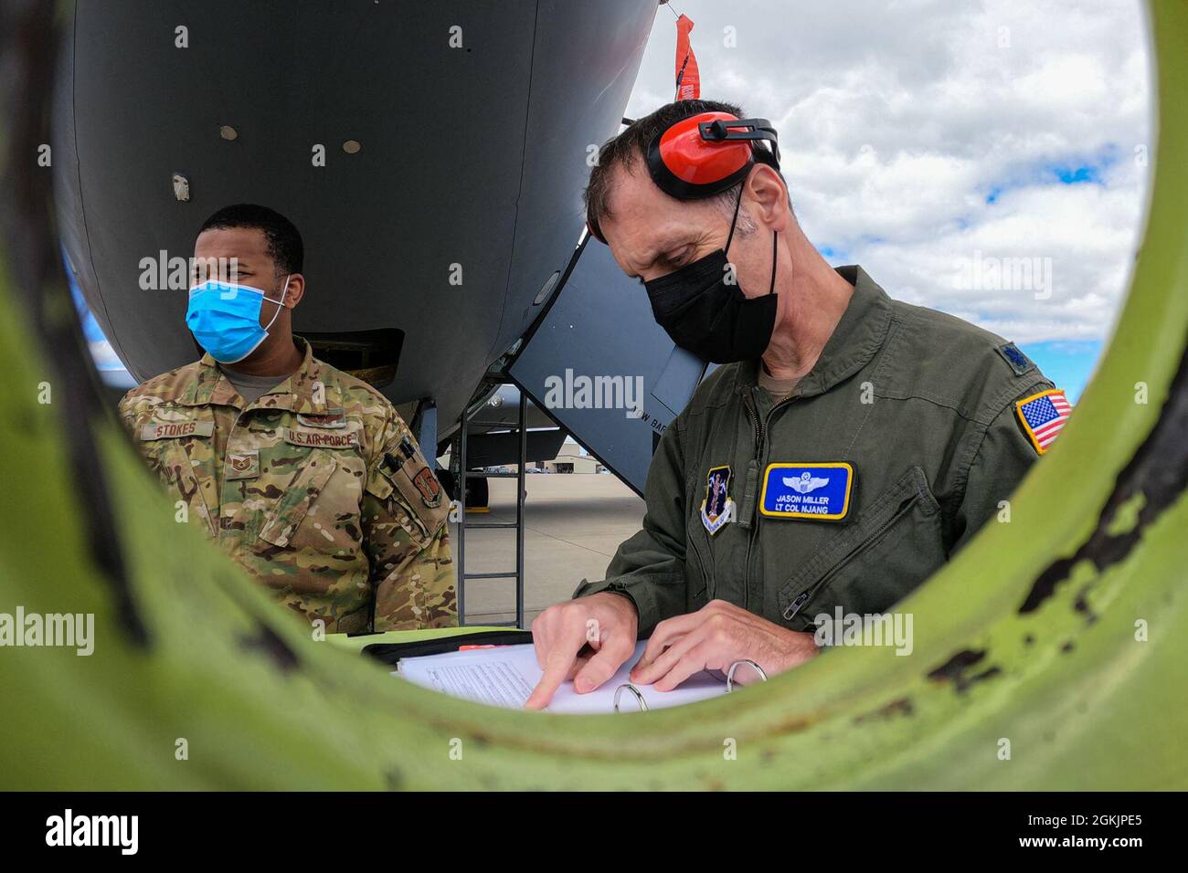 U.S. Air Force Lt. Col. Jason Miller goes over maintenance paperwork by ...