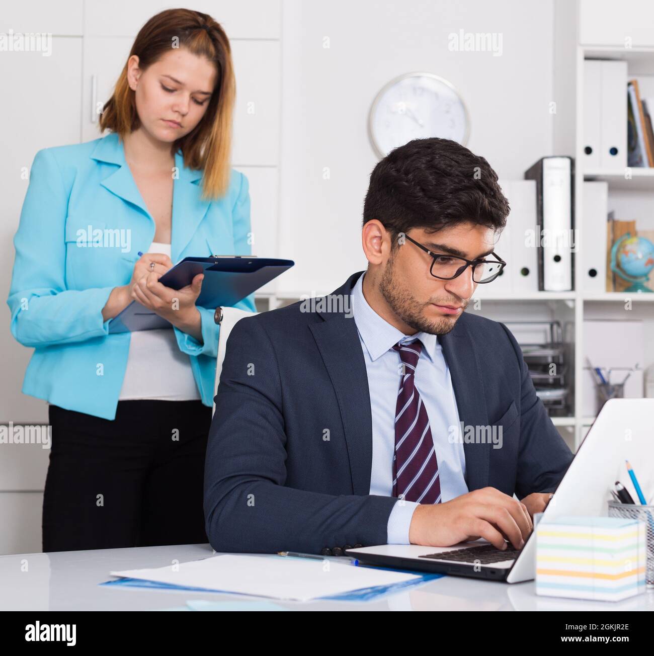 Secretary writing boss instructions Stock Photo - Alamy
