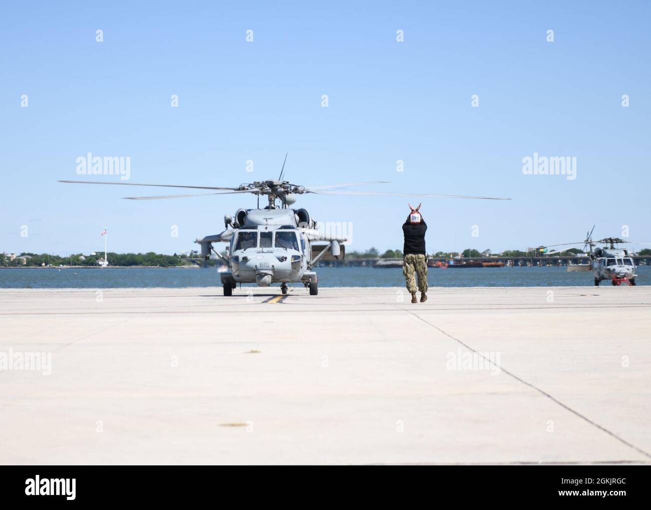 A Sailor assigned to Helicopter Sea Combat Squadron 11 (HSC-11) directs ...