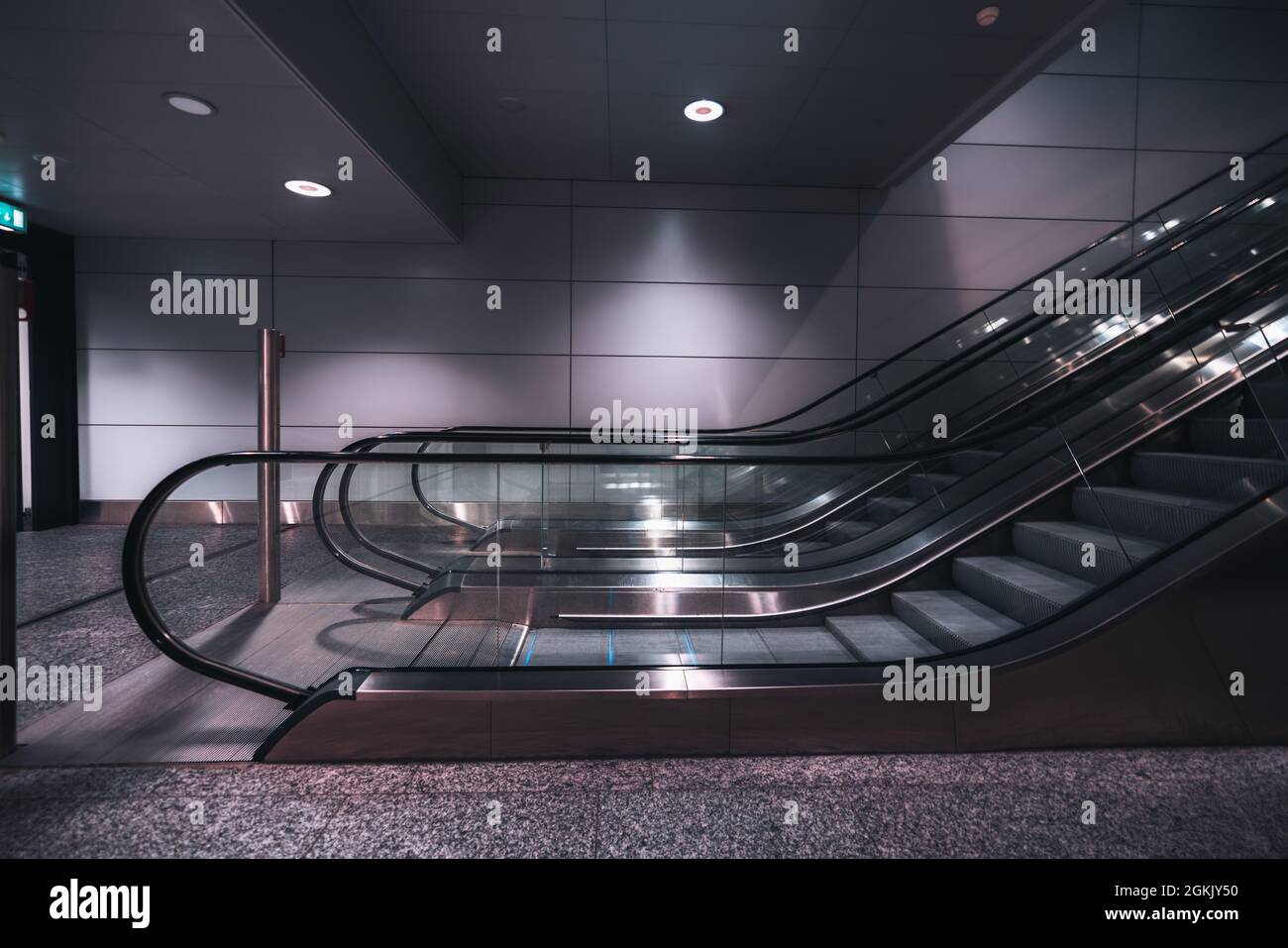 A side view of a modern doubled escalator made of metal and glass ...