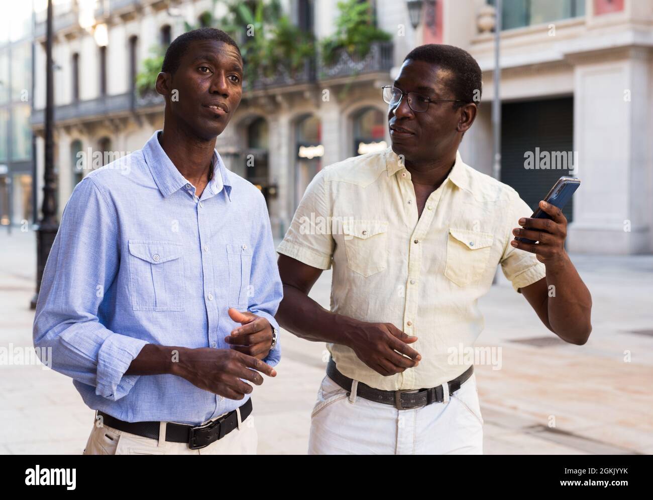 African American talking with friend during walk through city Stock ...