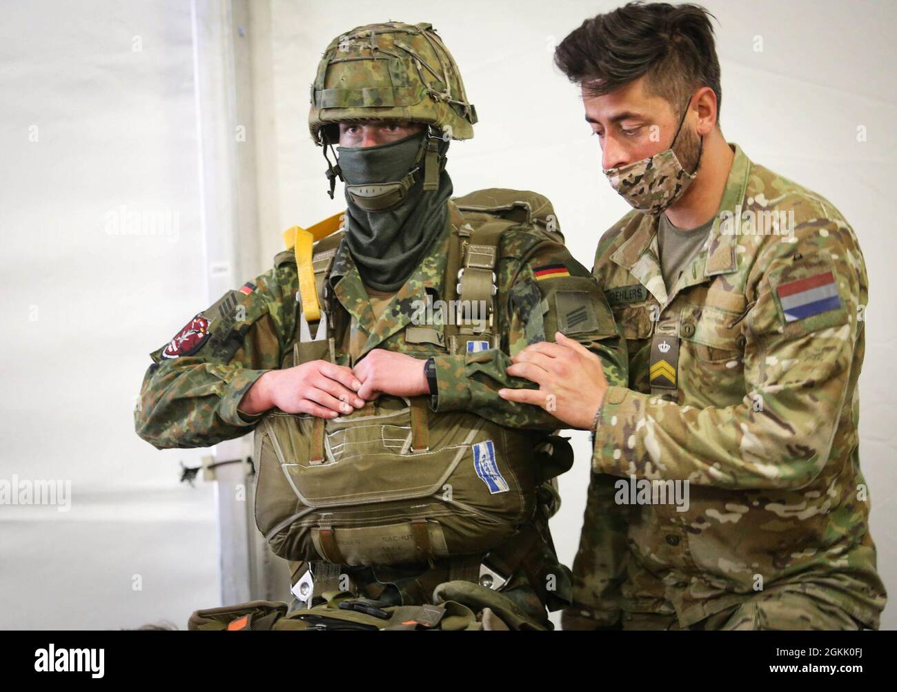 A Dutch soldier assigned to the 11th Airborne Battalion helps a German ...