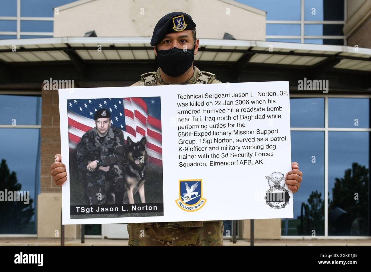 An Airman from the 460th Security Forces Squadron holds up a poster on ...