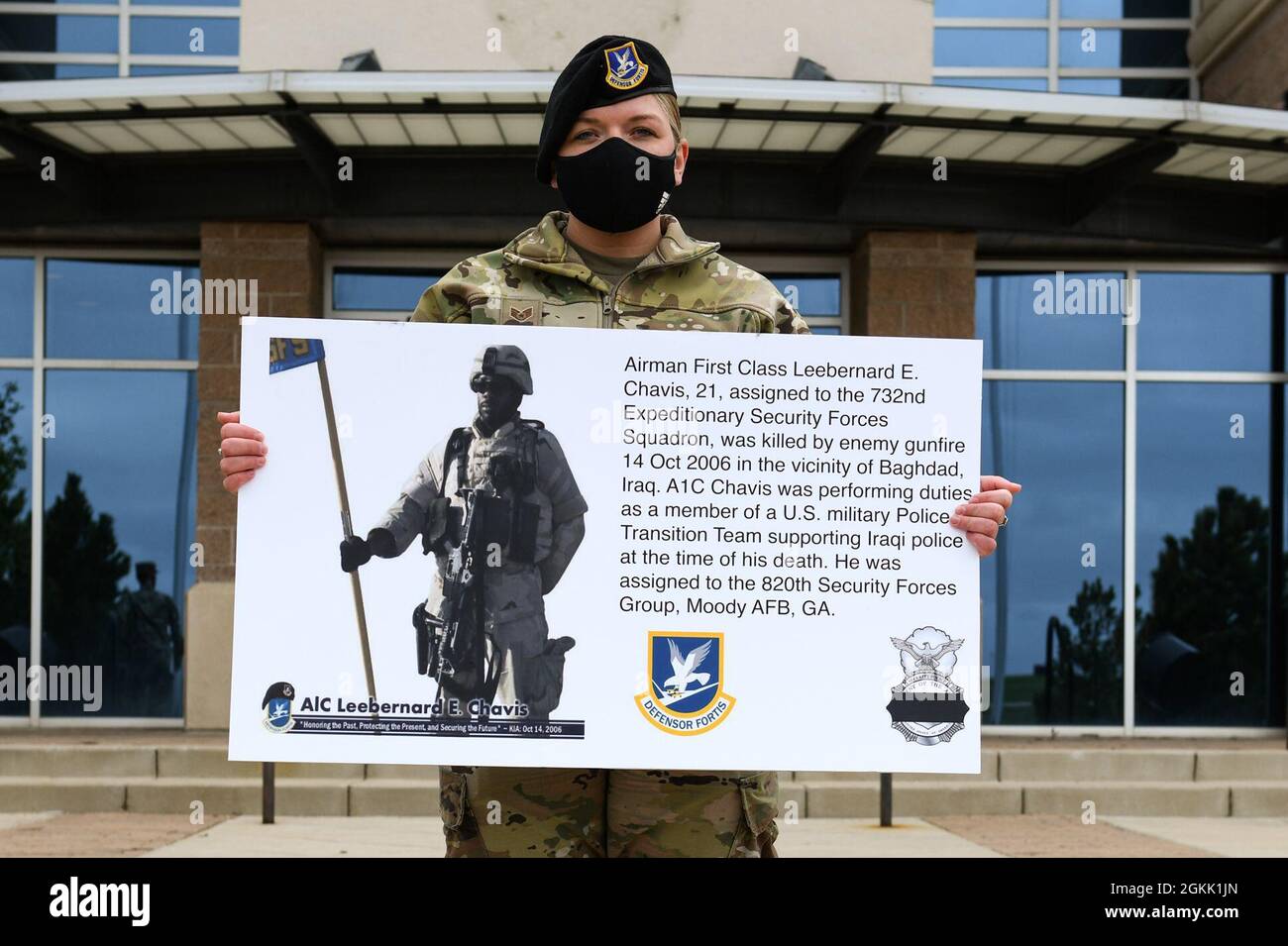 An Airman from the 460th Security Forces Squadron holds up a poster on ...