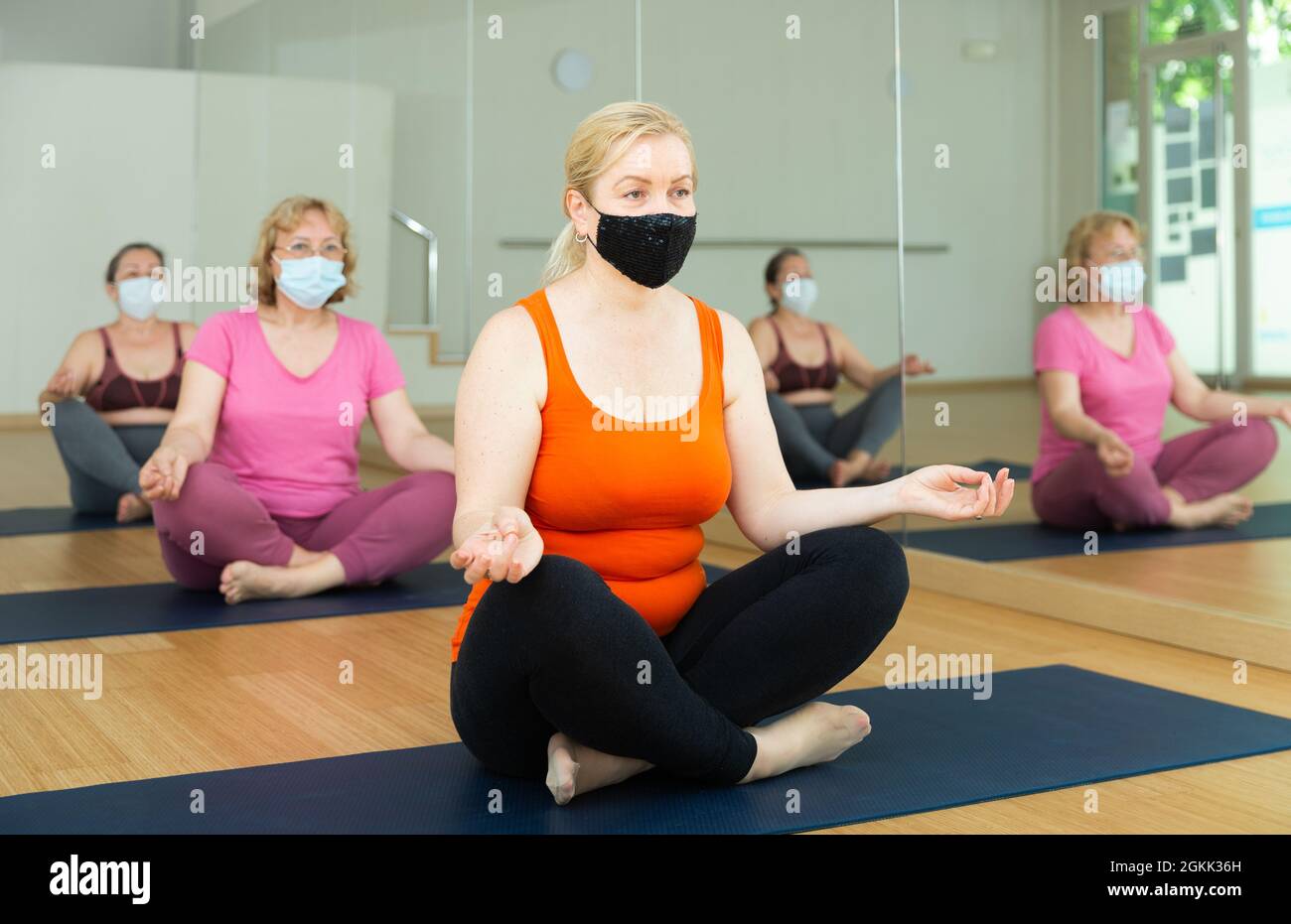 Ladies in masks are sitting in a lotus pose Stock Photo - Alamy