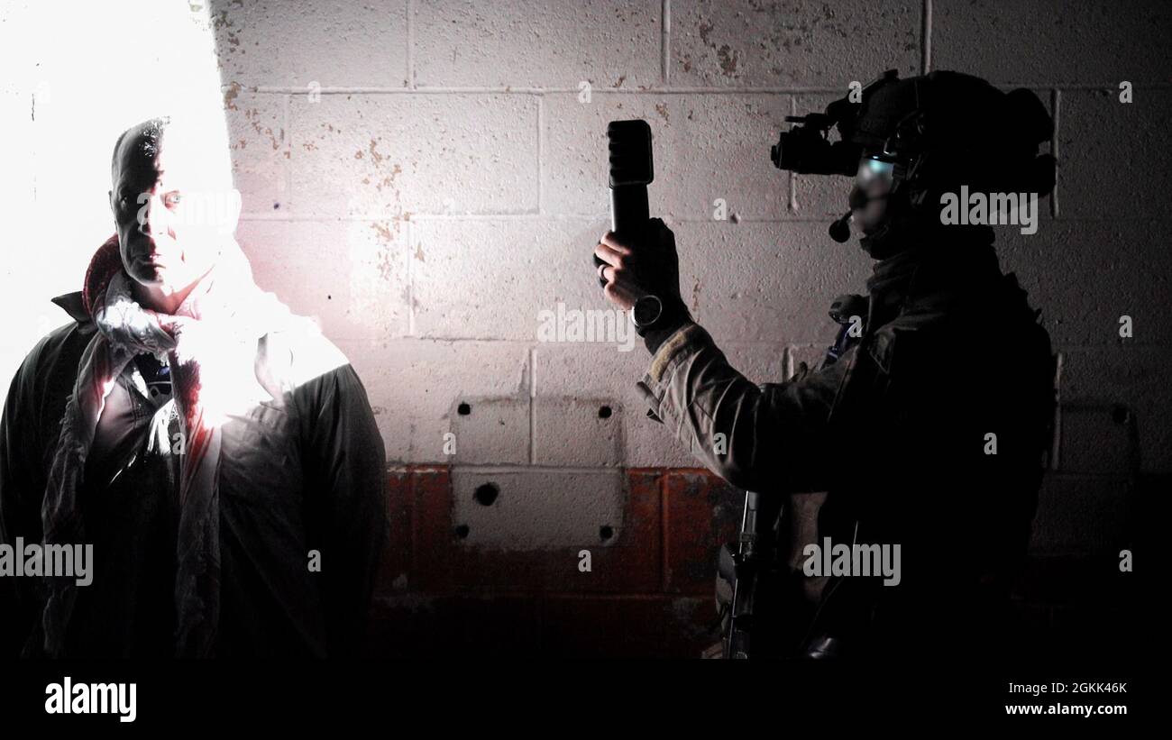 A Marine Raider photographs a simulated detainee during a RAVEN unit ...