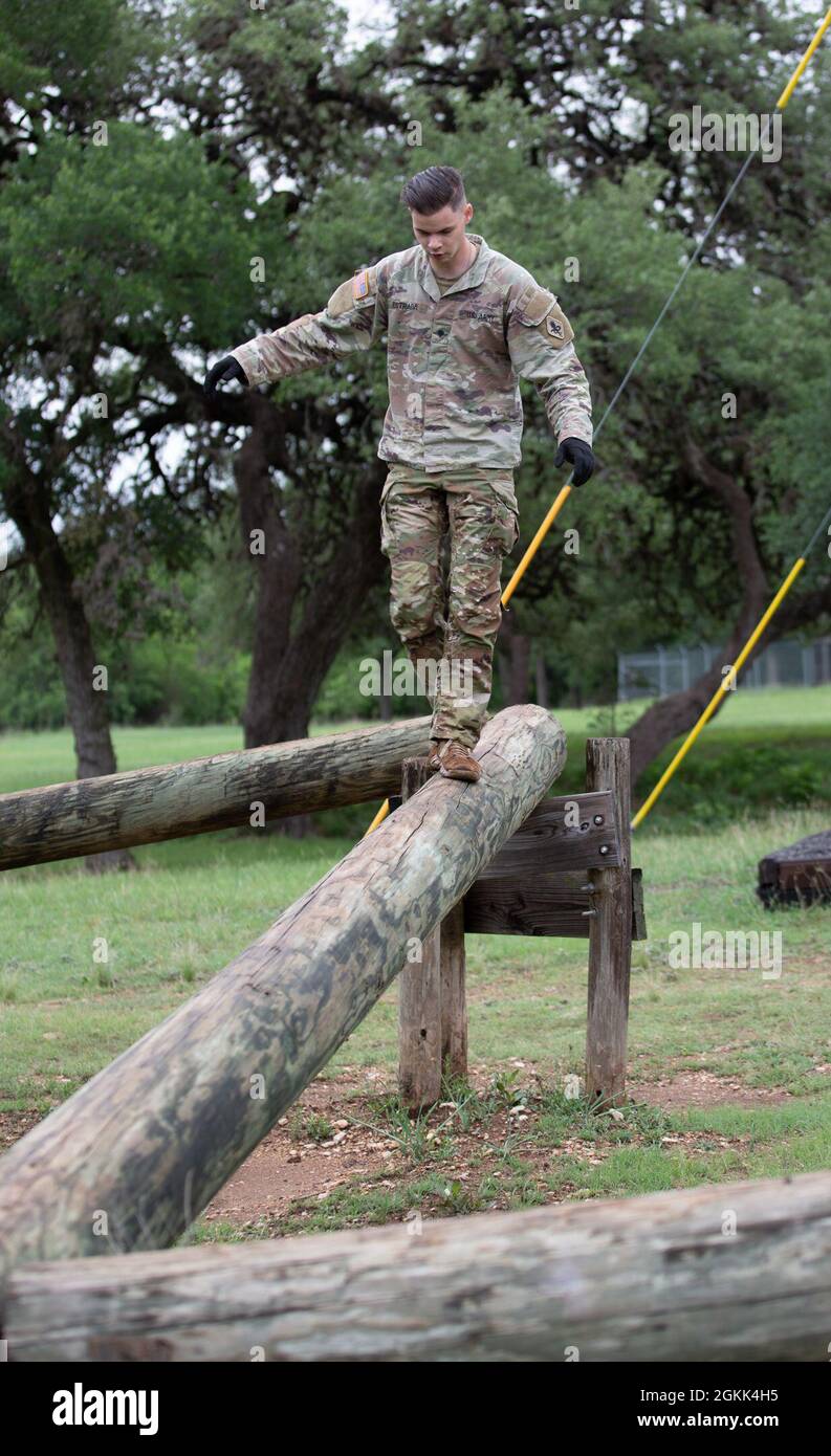 U.S. Army Spc. Jesse Estrada crosses the sloped logs while competing in ...