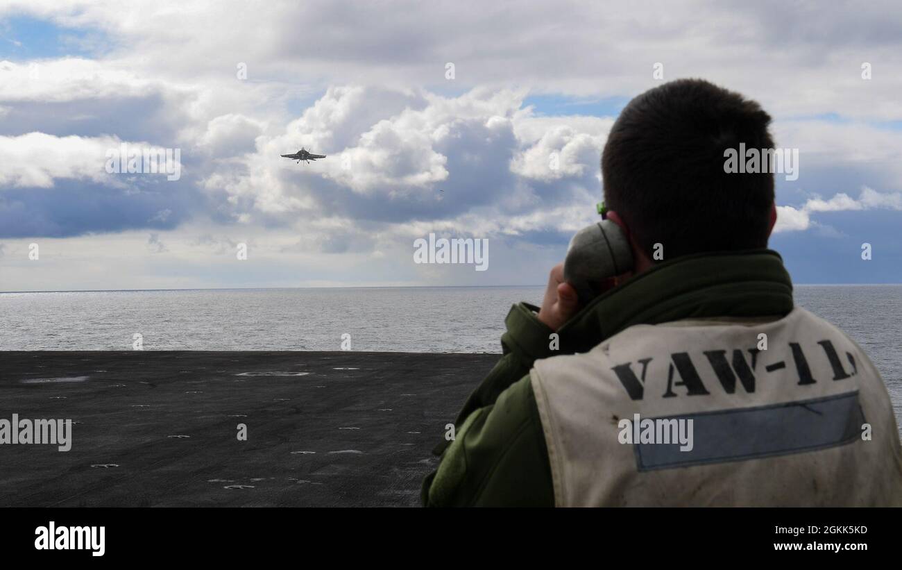 U.S. Navy Lt. Tyler Ballard, a Landing Signal Officer, guides the pilot ...