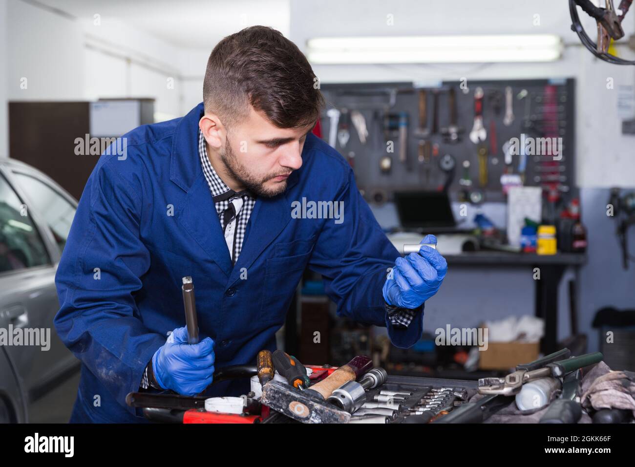 Professional worker is looking instruments for repair car Stock Photo ...