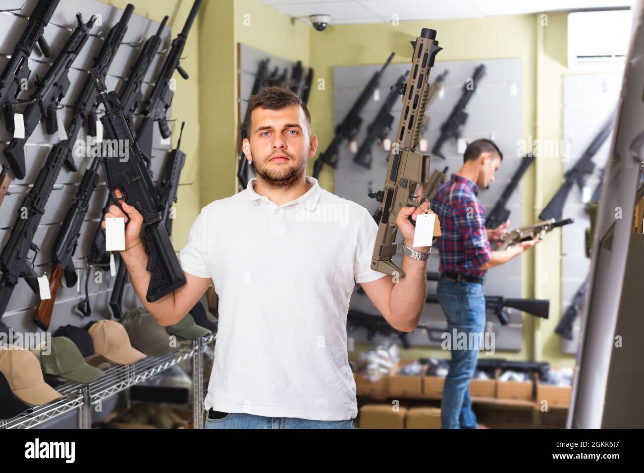 Customer man is choosing air-powered gun Stock Photo - Alamy