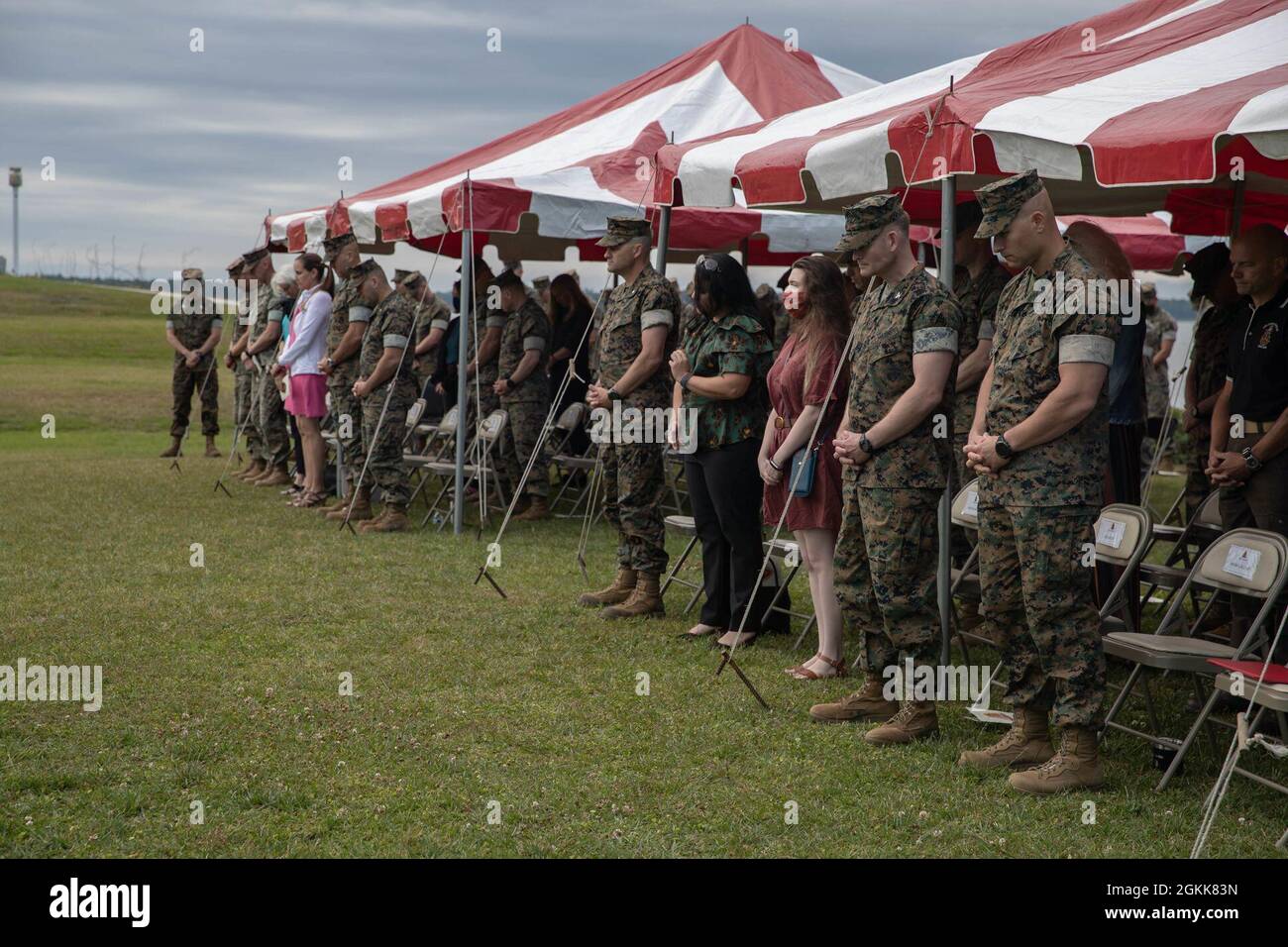U.S. Marines, friends and families bow their heads to pray during an ...