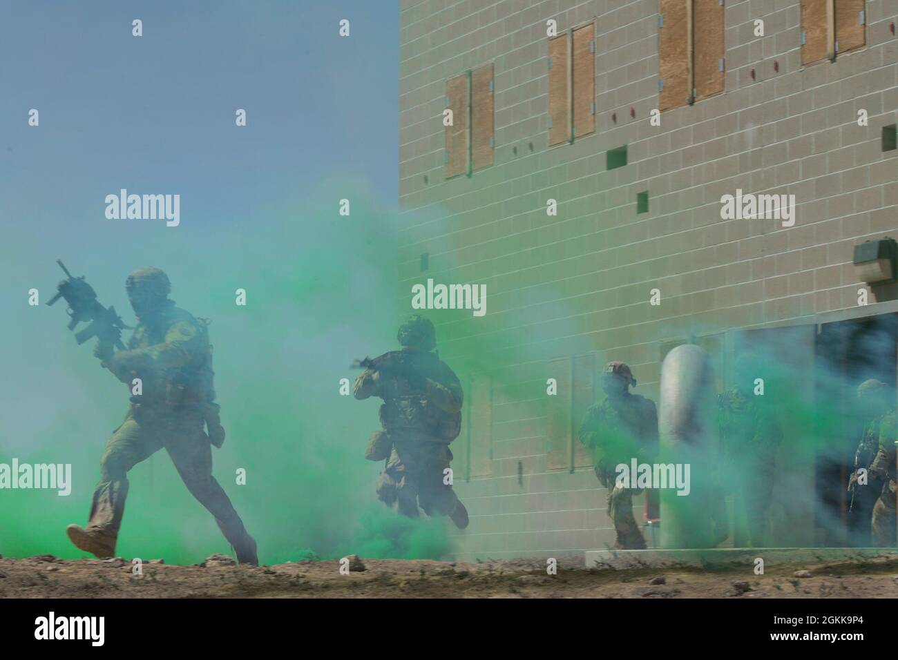 Using smoke grenades for extra cover, soldiers run across an open space ...