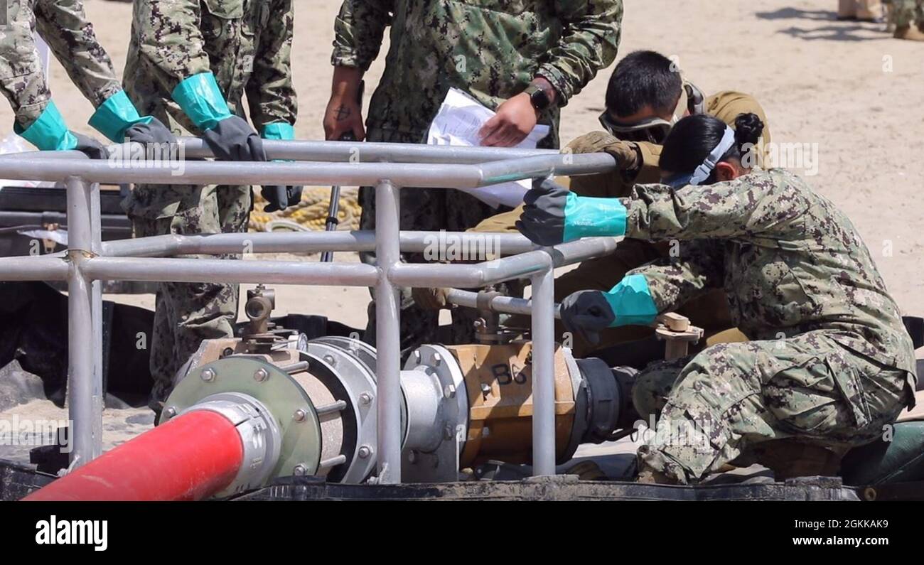 U.S. Army Soldiers and U.S. Navy Sailors work together to connect a ...