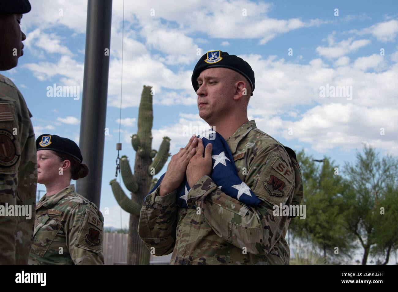 A defender holds the flag during a retreat ceremony at Davis-Monthan ...