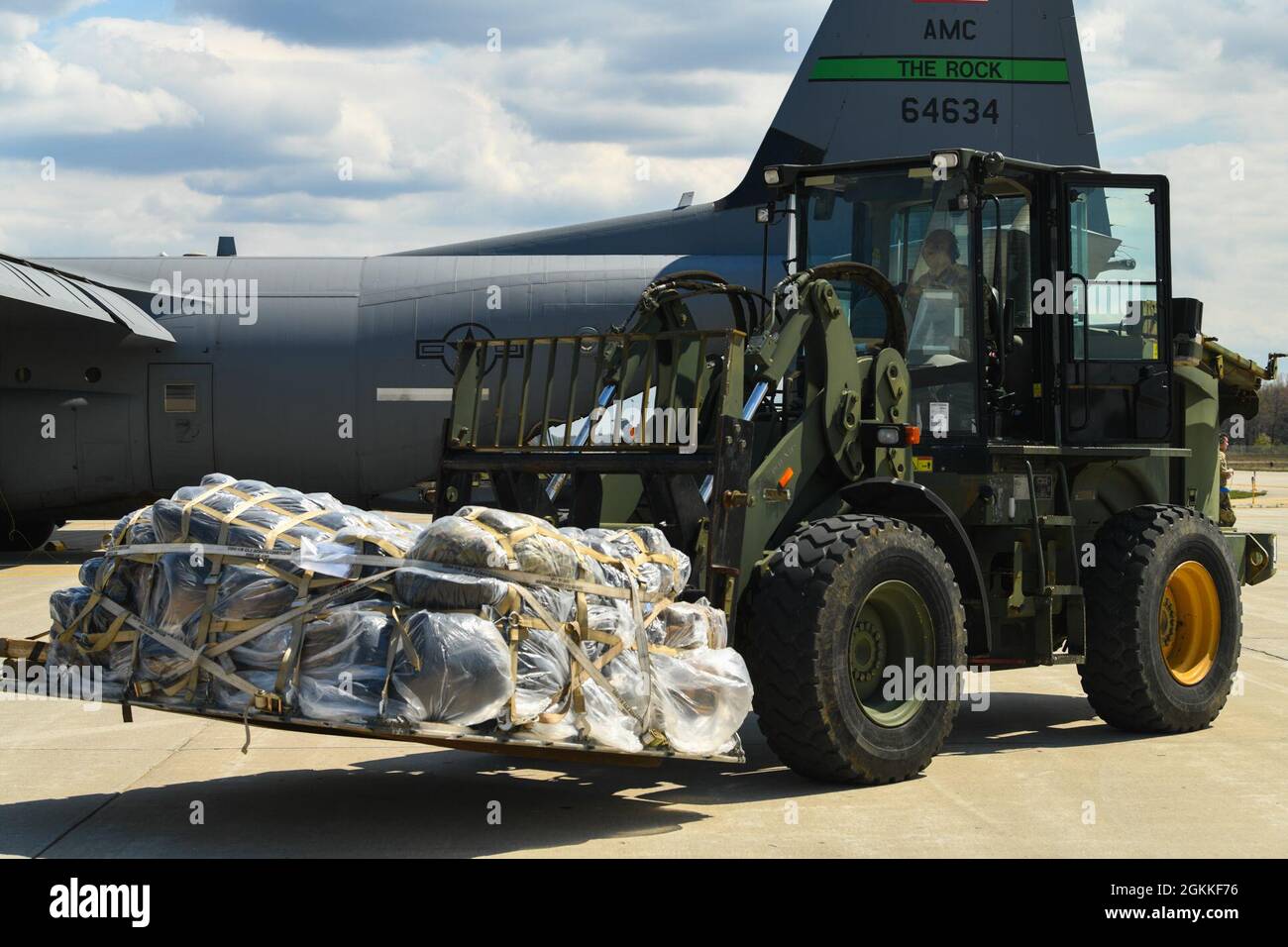 An Airman transports supplies and gear from a C-130J Super Hercules ...