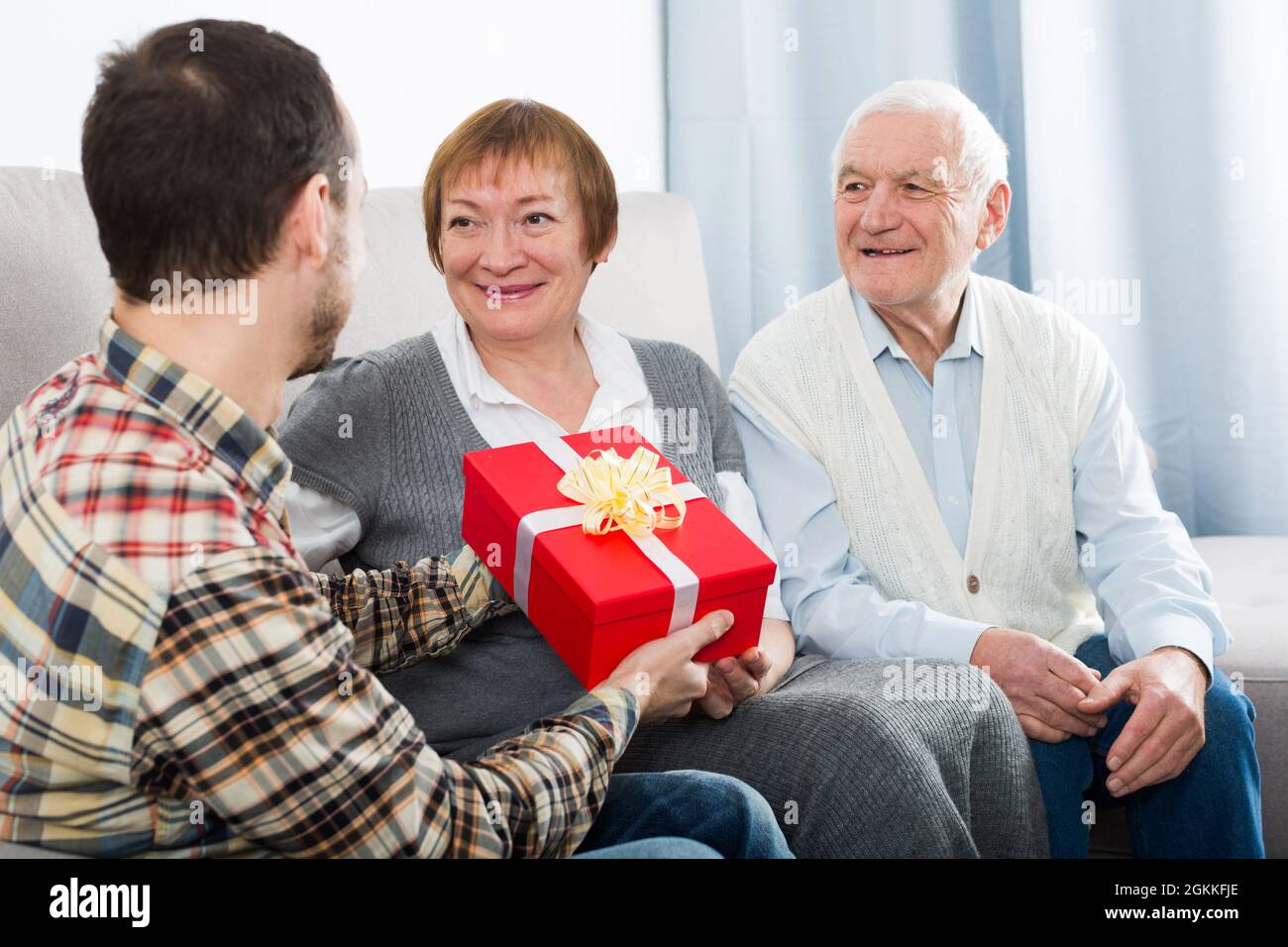 Son giving presents to parents Stock Photo - Alamy