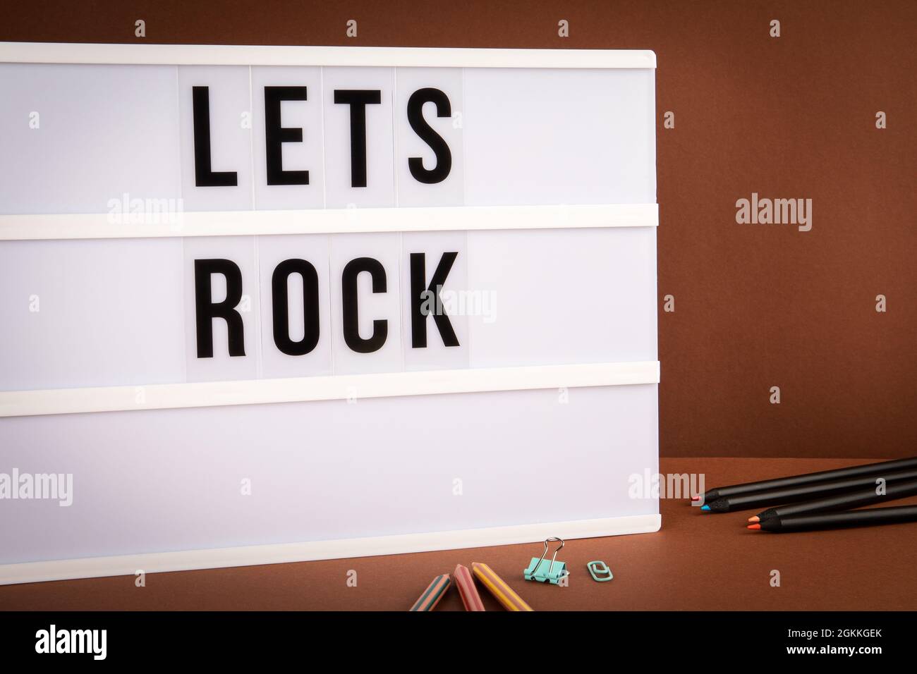 LETS ROCK. Light box with text on a brown background Stock Photo - Alamy