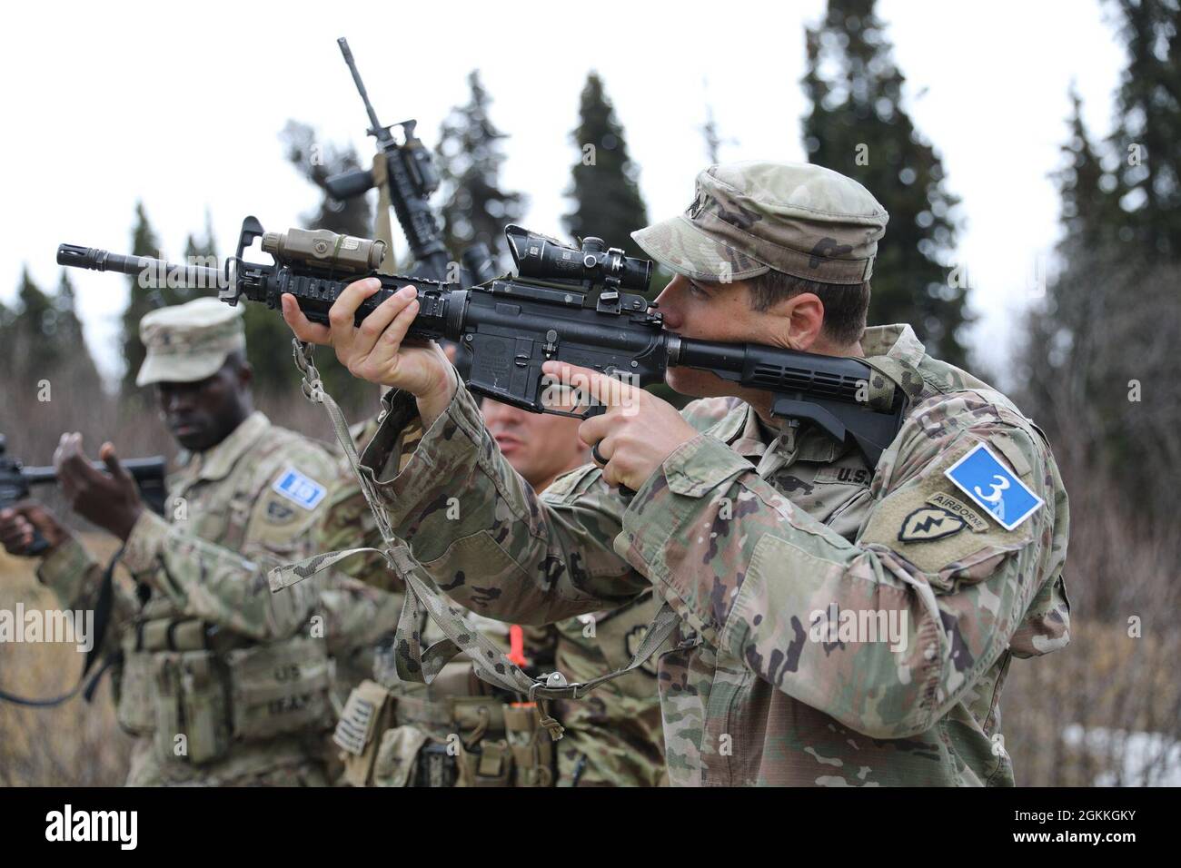 USARAK Best Warrior competitors look through the sites of an M4 during ...