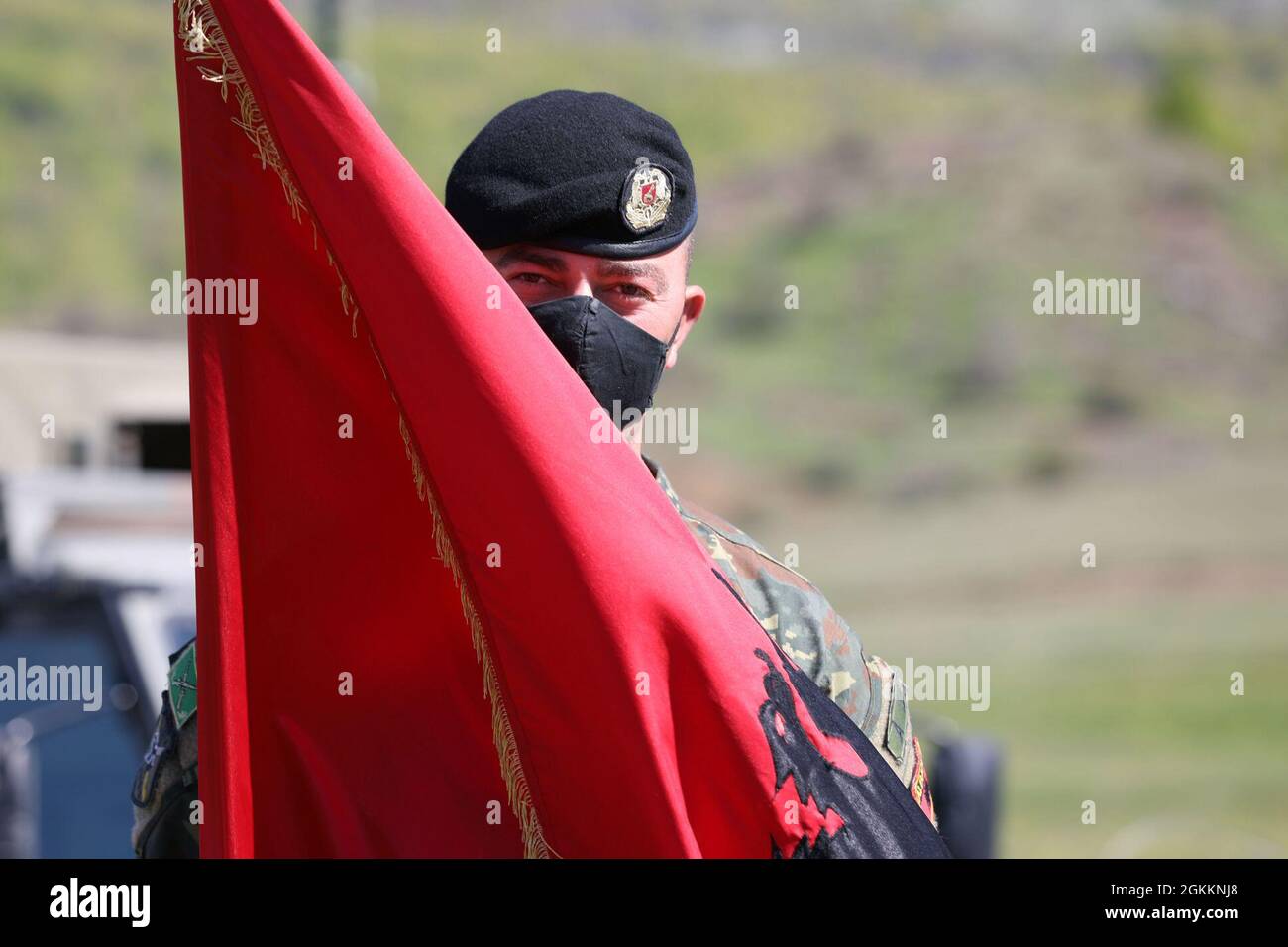 An Albanian soldier stands behind his flag during a joint training ...