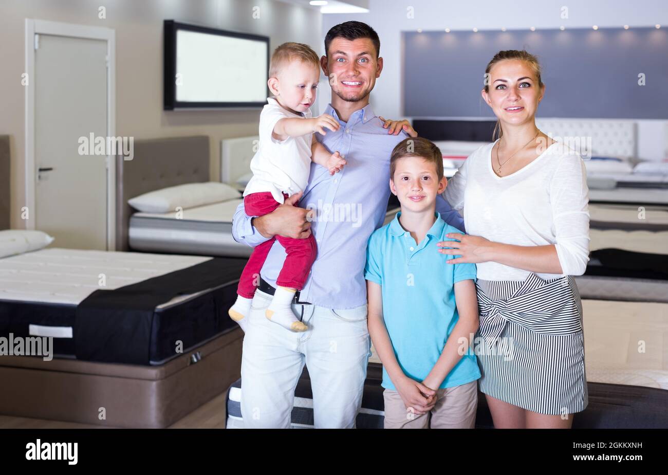 Portrait of family visiting furniture salon in search of new mattress ...