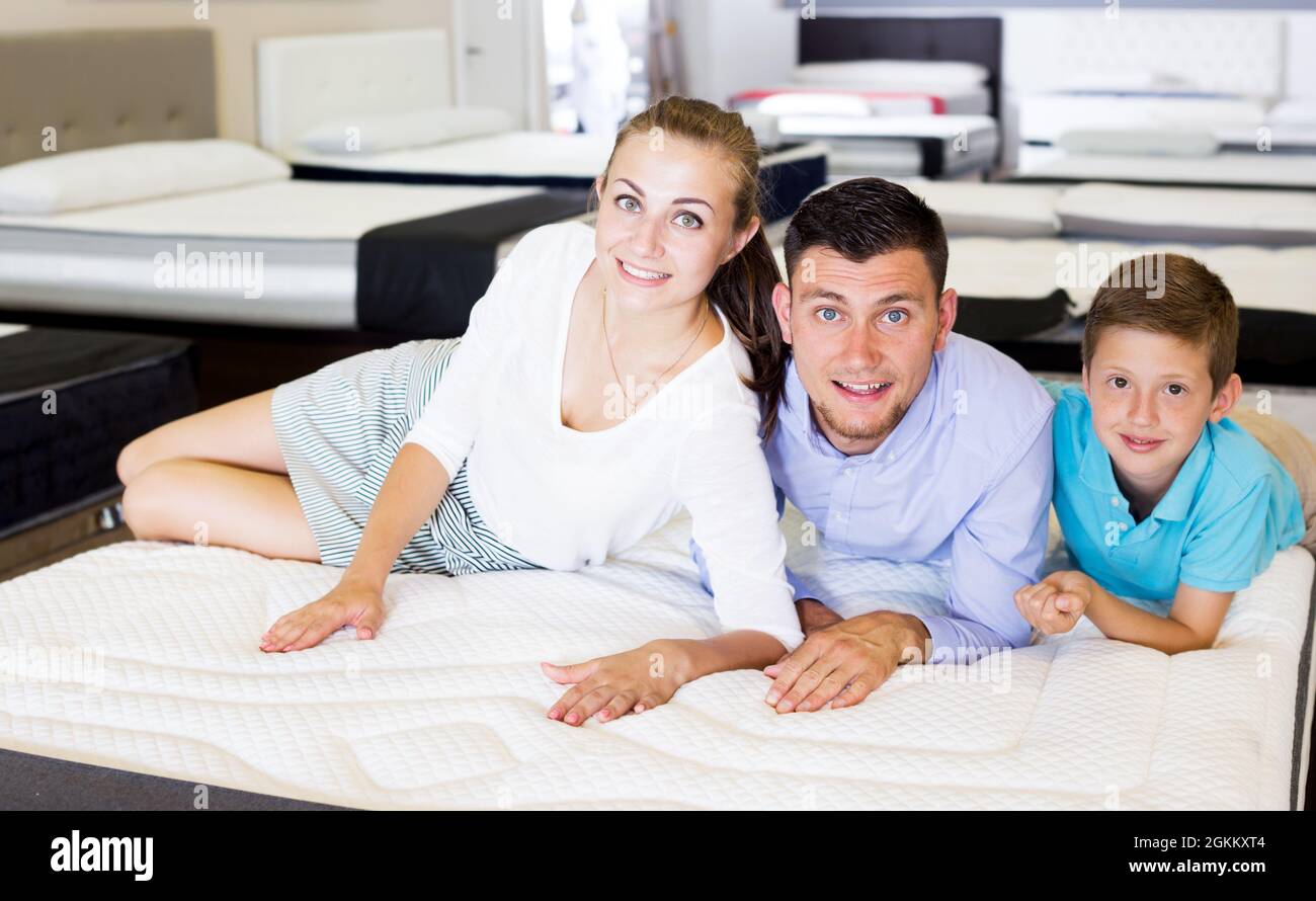 Parents with young son testing mattress Stock Photo - Alamy