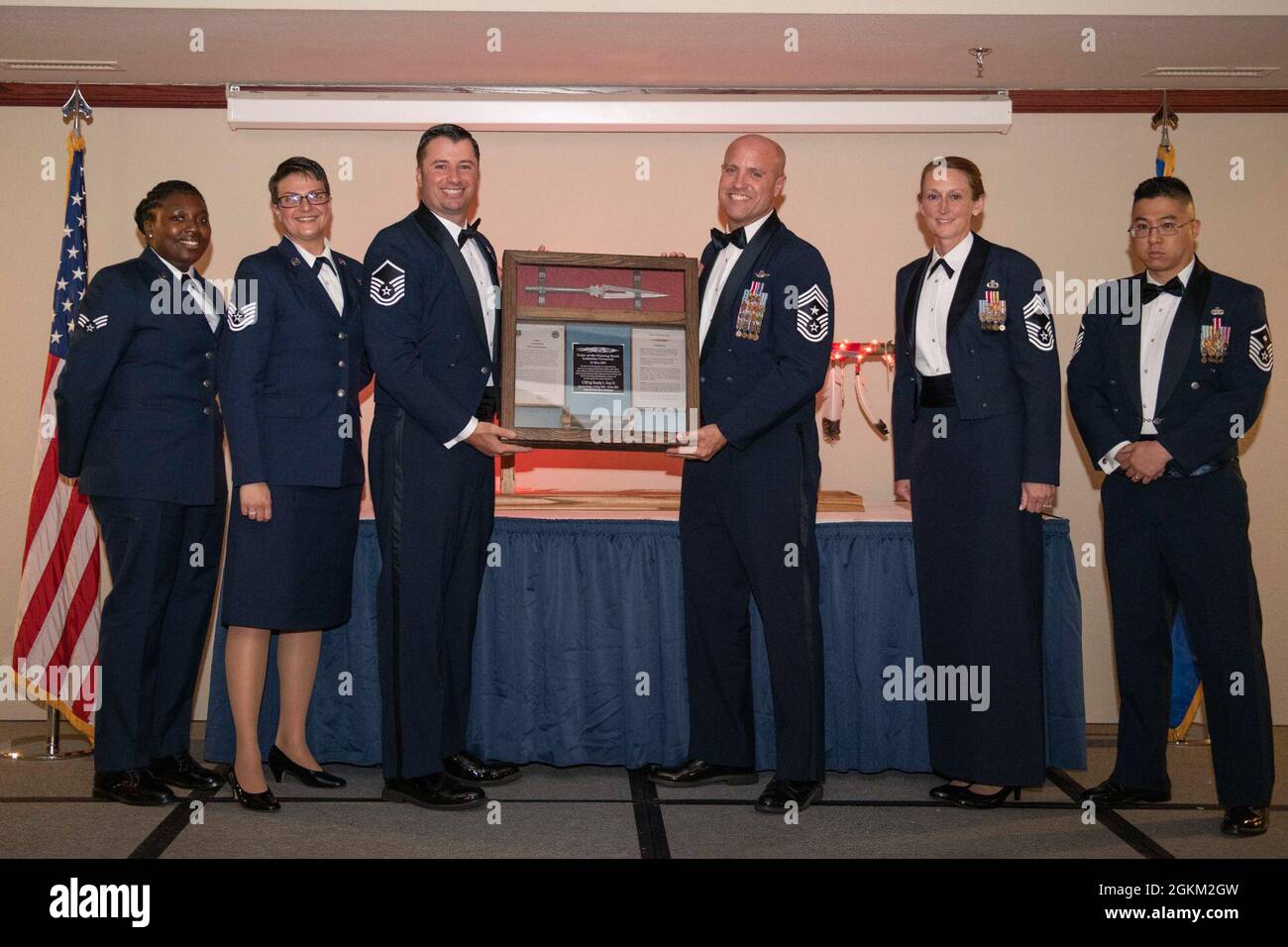 Members of the 97th Air Mobility Wing (AMW) present a shadow box to ...