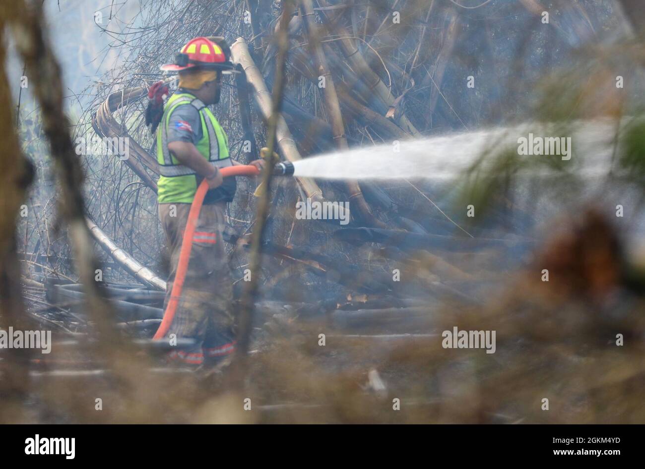 A fireman uses a water hose to put out a fire at Cayey, Puerto Rico ...