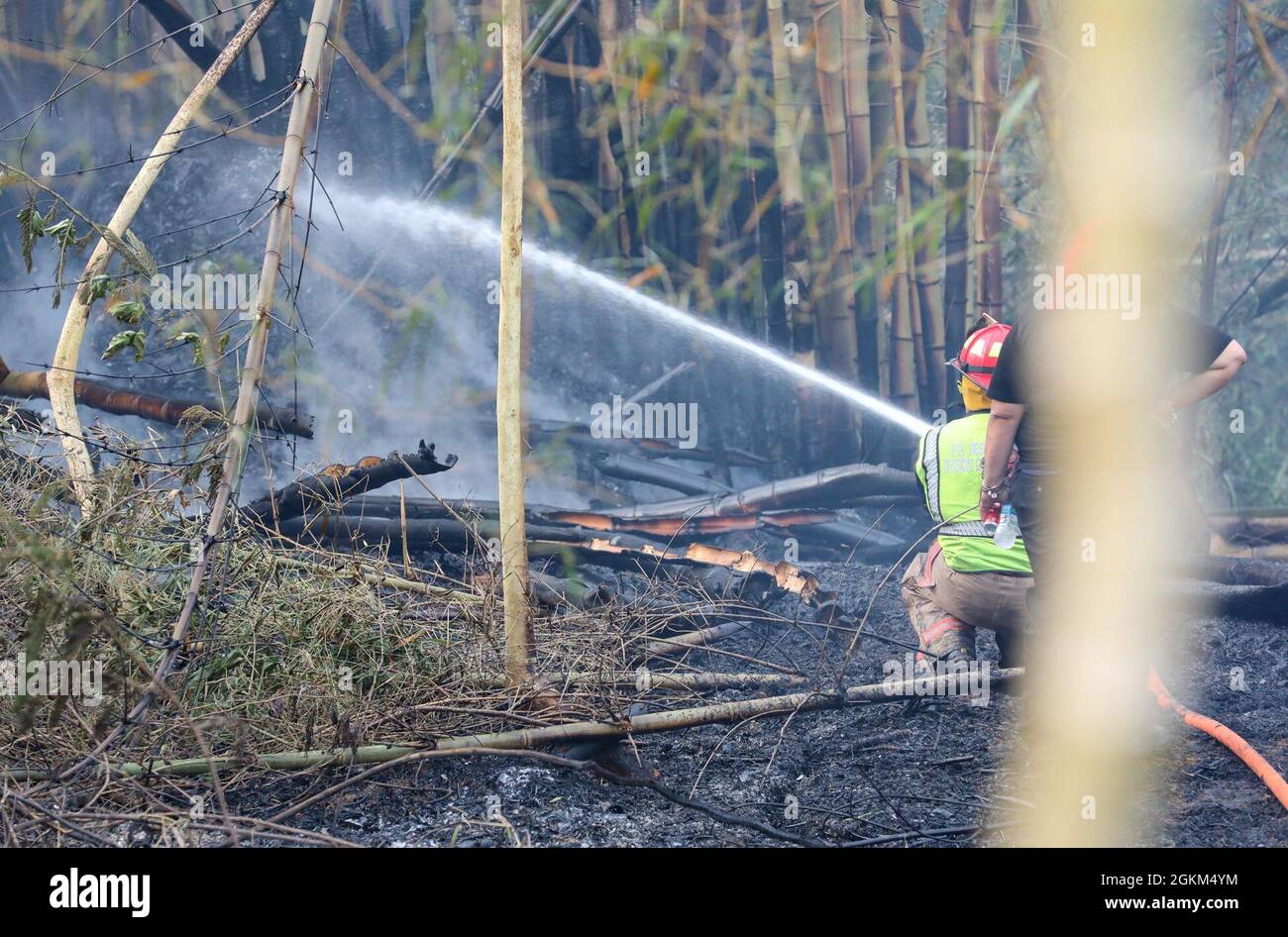 A fireman uses a water hose to put out a fire at Cayey, Puerto Rico ...