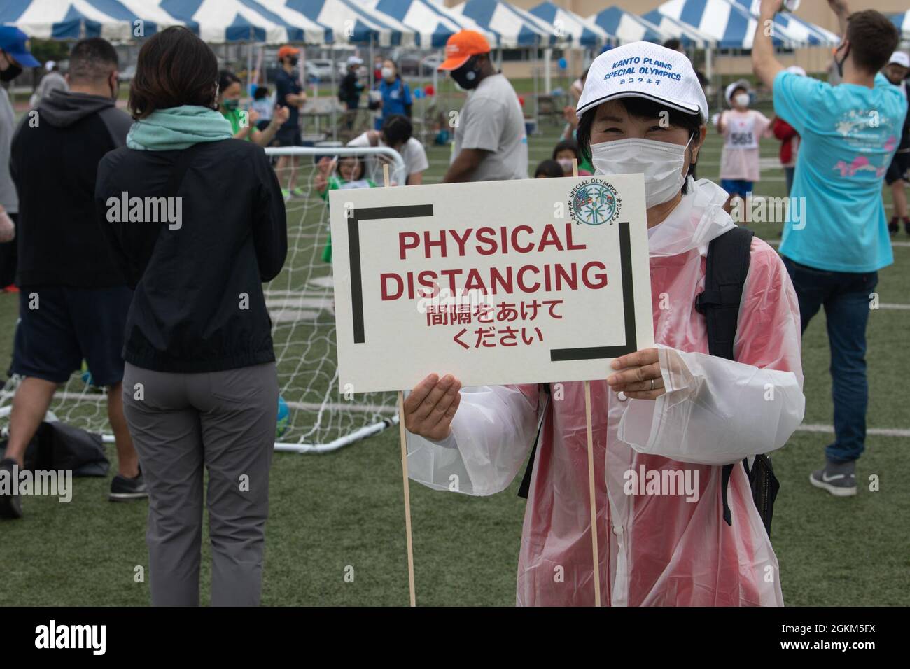 A volunteer displays a physical distancing sign during the Kanto Plains ...