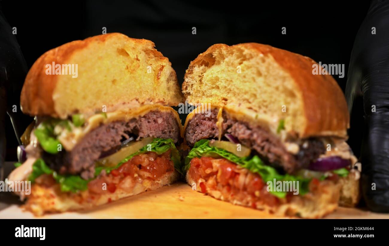 Cut craft burger is cooking on black background. Consist sauce s Stock ...