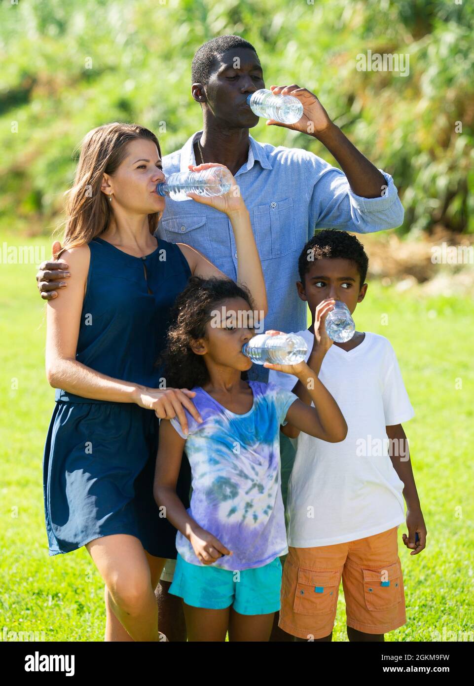 Family drinking water in park Stock Photo - Alamy
