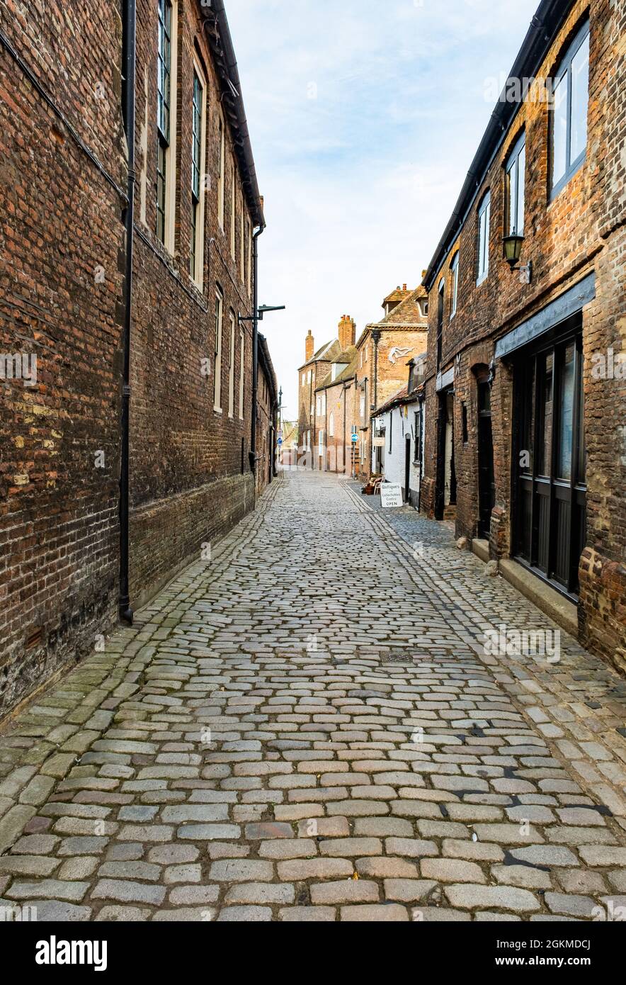 Narrow alley way with historic brick buildings and a cobbled street ...