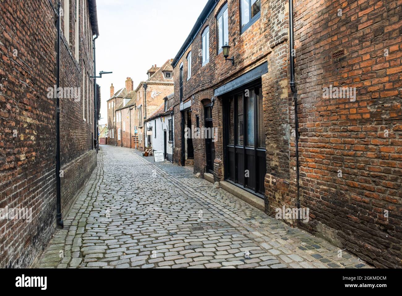 Narrow alley way with historic brick buildings and a cobbled street ...