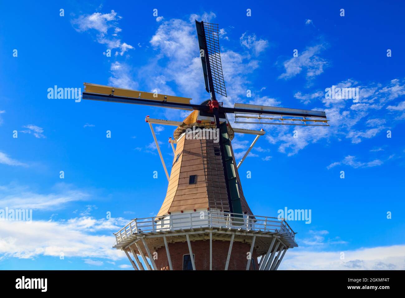 A replica of a 17th-century Dutch windmill against a bright blue sky ...