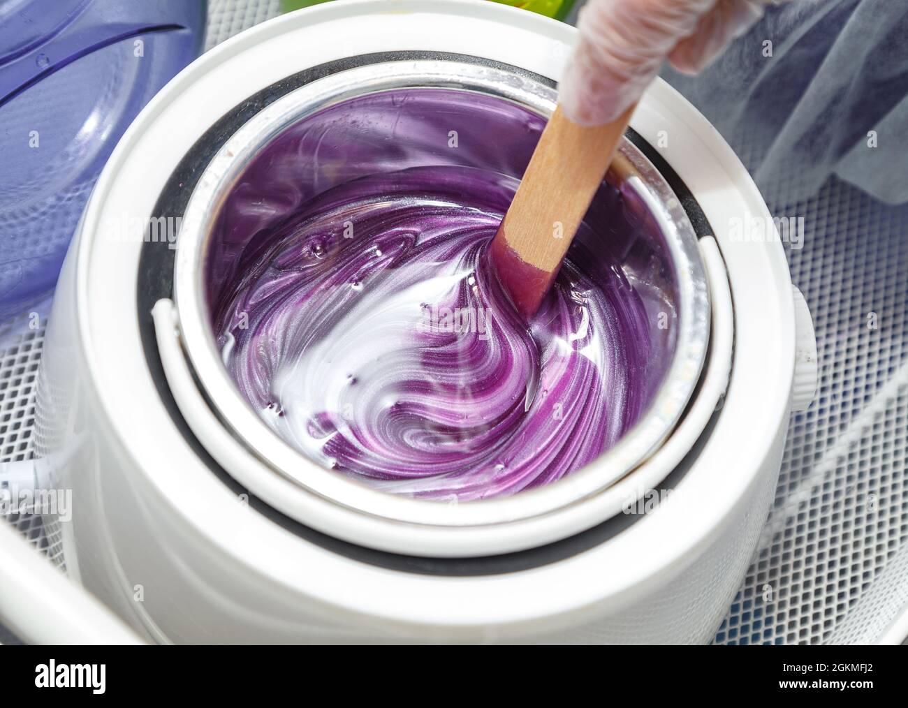 Shot of melted purple wax on wooden stick for depilation Stock Photo ...
