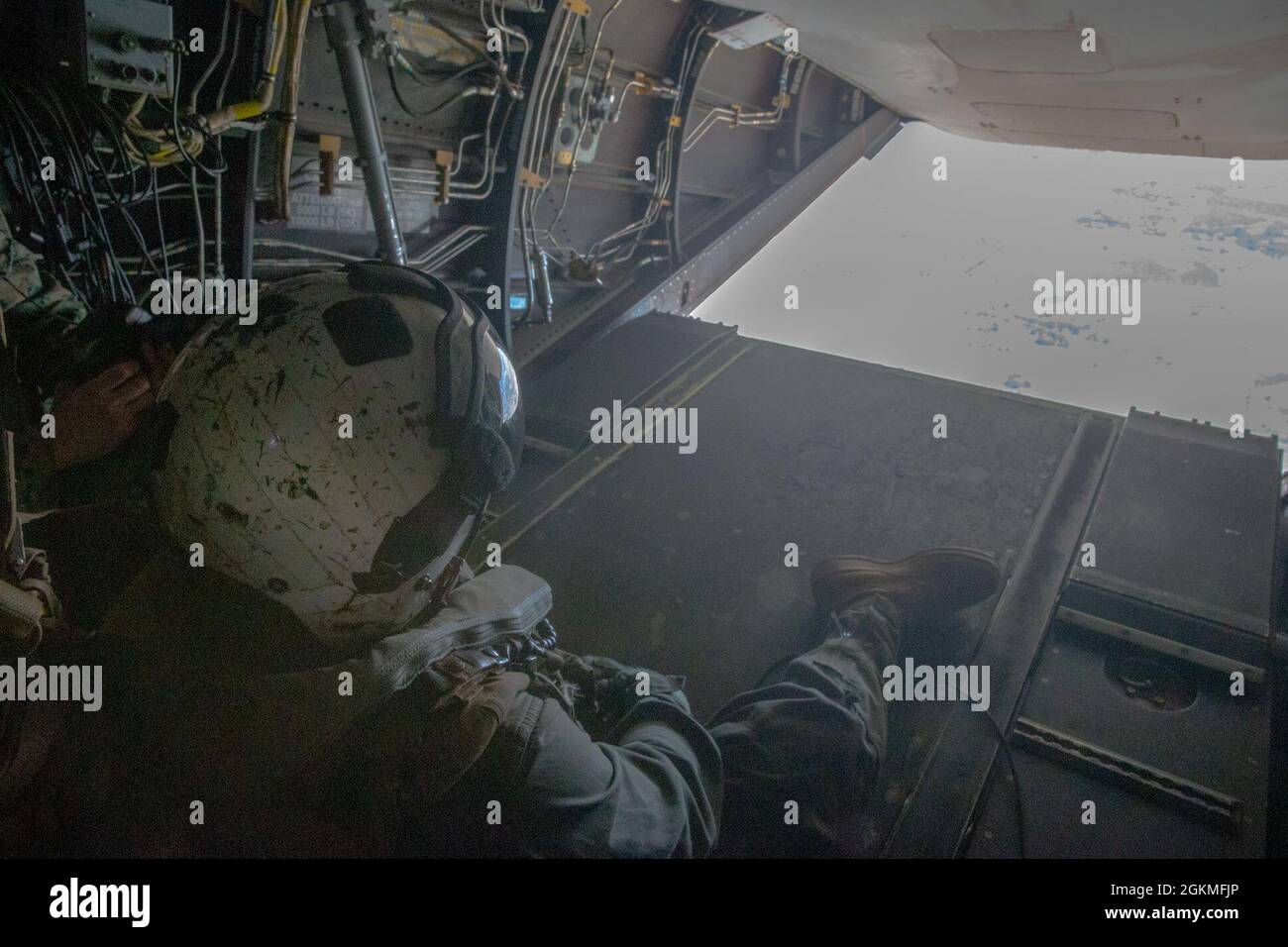 A U.S. Marine Corps Air Crew Chief sits in the back of an MV-22B Osprey ...