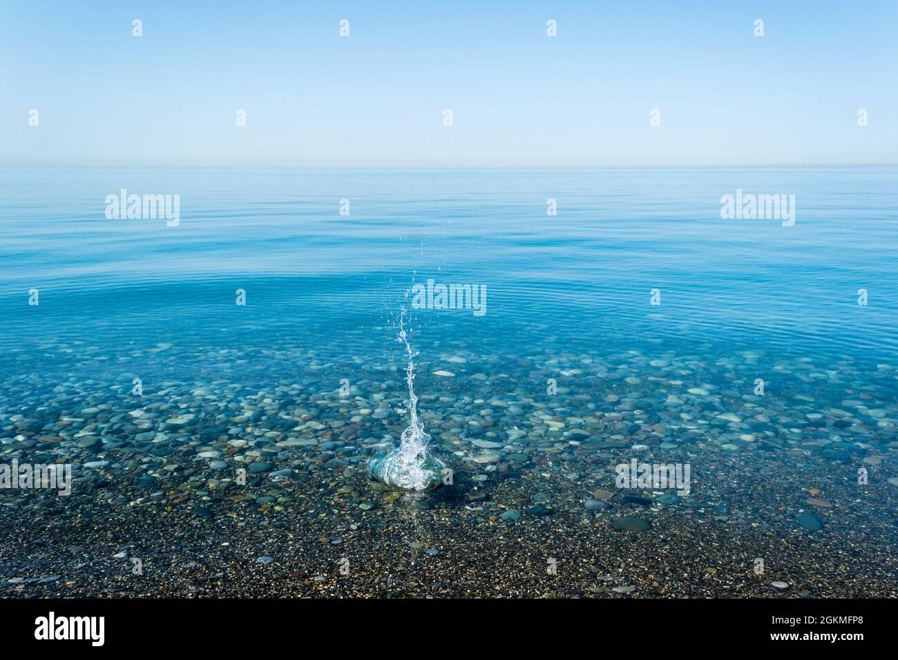 Water splatter on the sea by stony shore, forming sprays and splashes ...