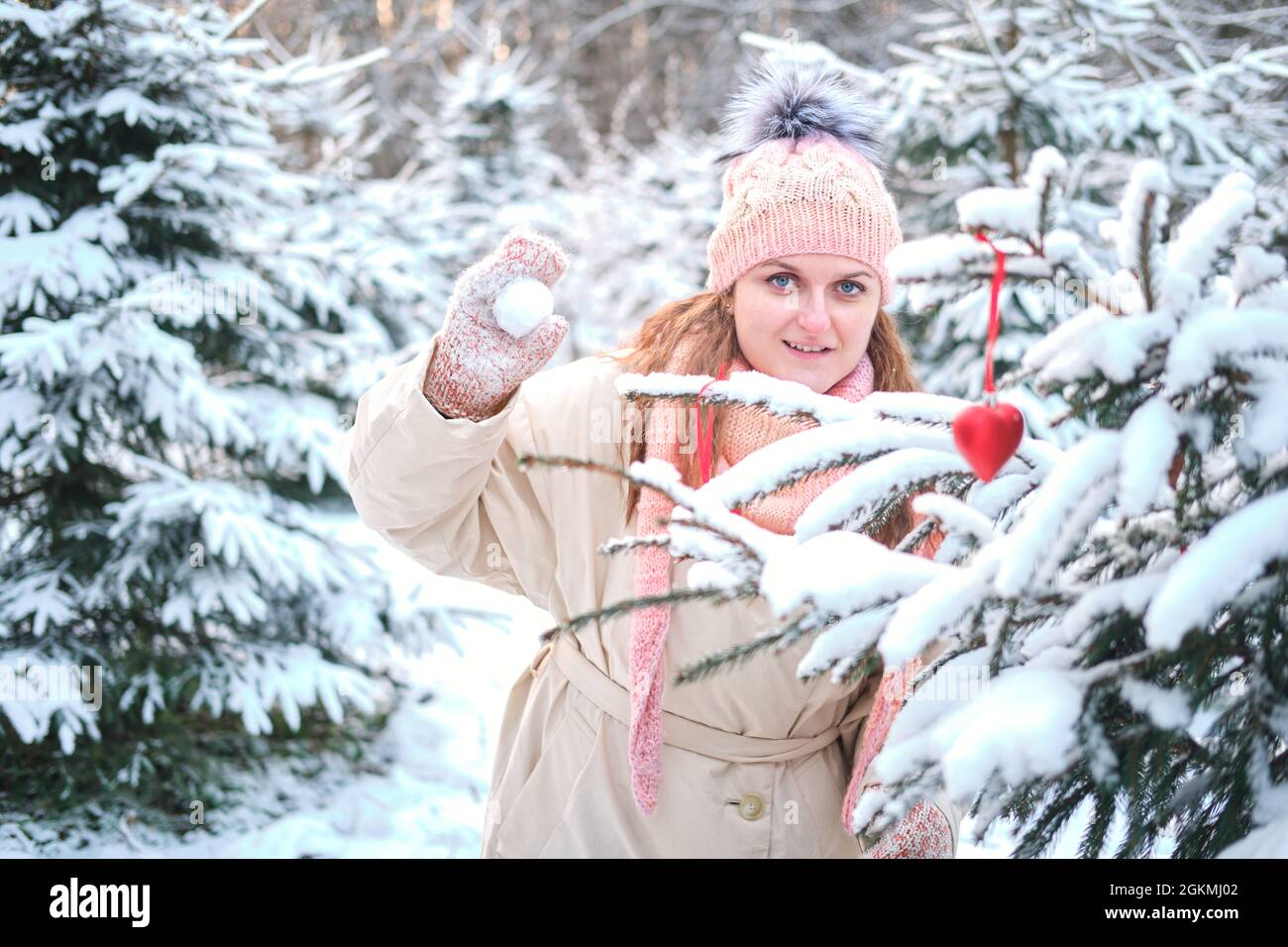Woman playing snowballs by the christmas tree in winter nature on new ...