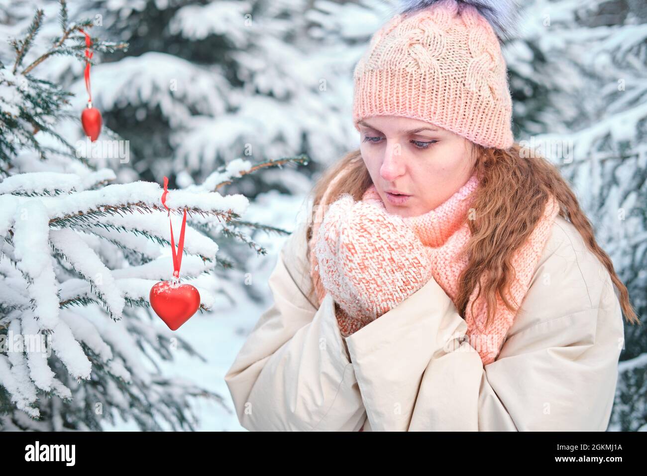 An adult woman is cold and blows on her hands to keep warm Stock Photo ...