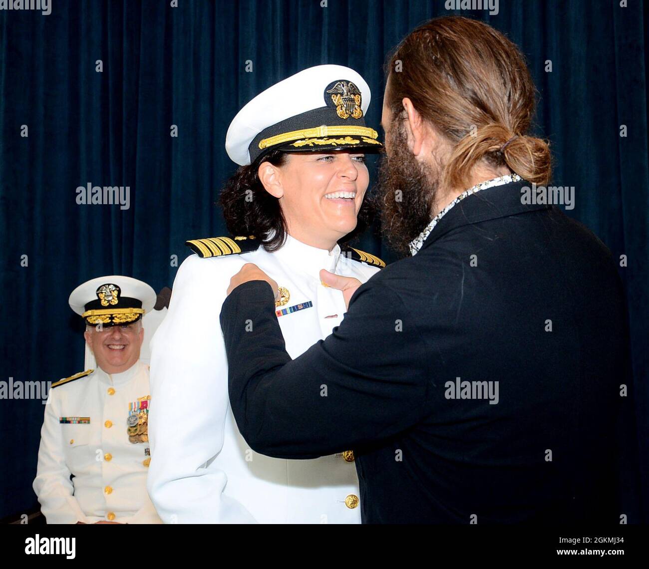 Mr. Jason Bain pins the Command Ashore Insignia on his wife, Capt ...