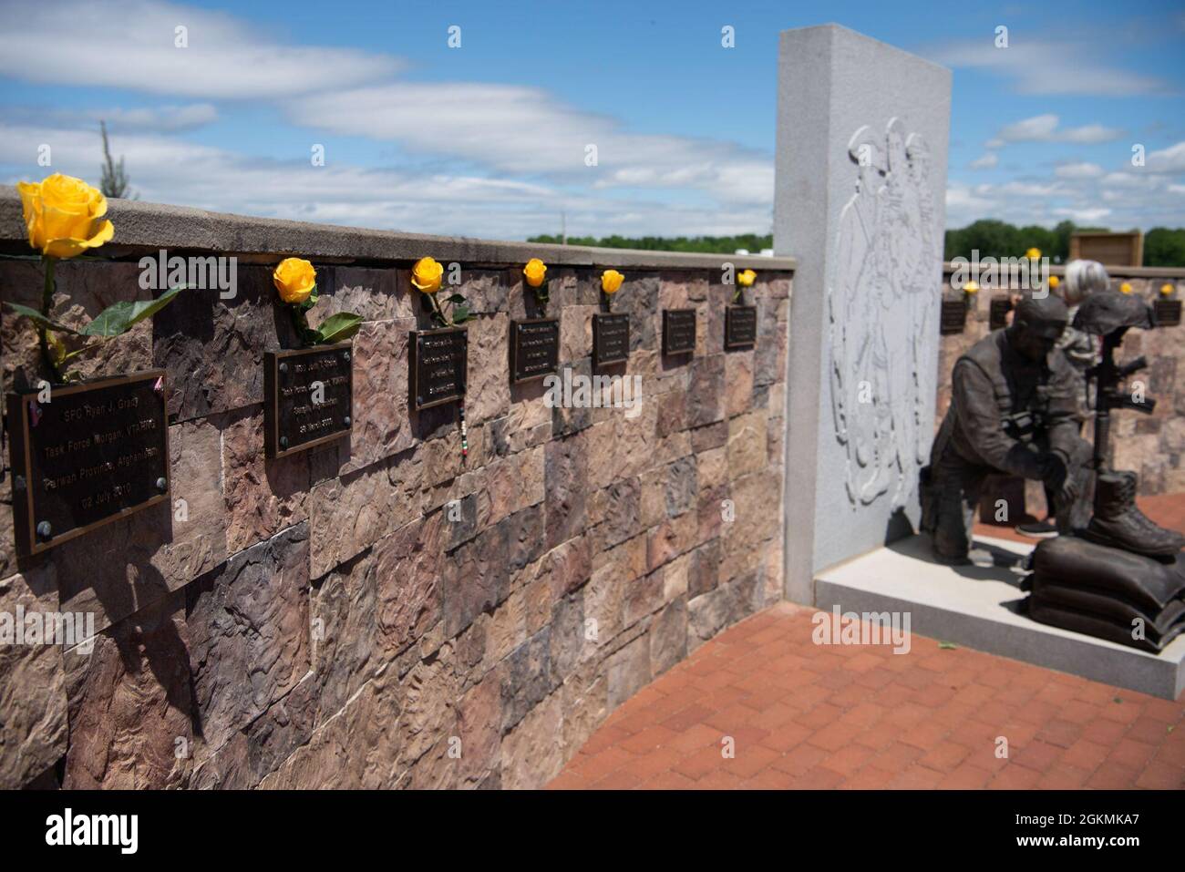 Yellow roses decorate memorial plaques for fallen service members after ...