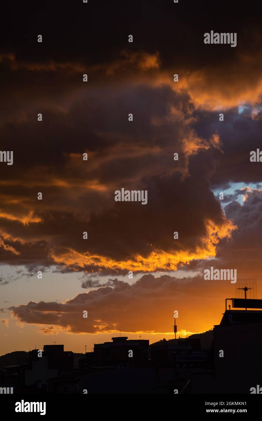 Dramatic stormy sunset sky with orange heavy clouds over city skyline ...