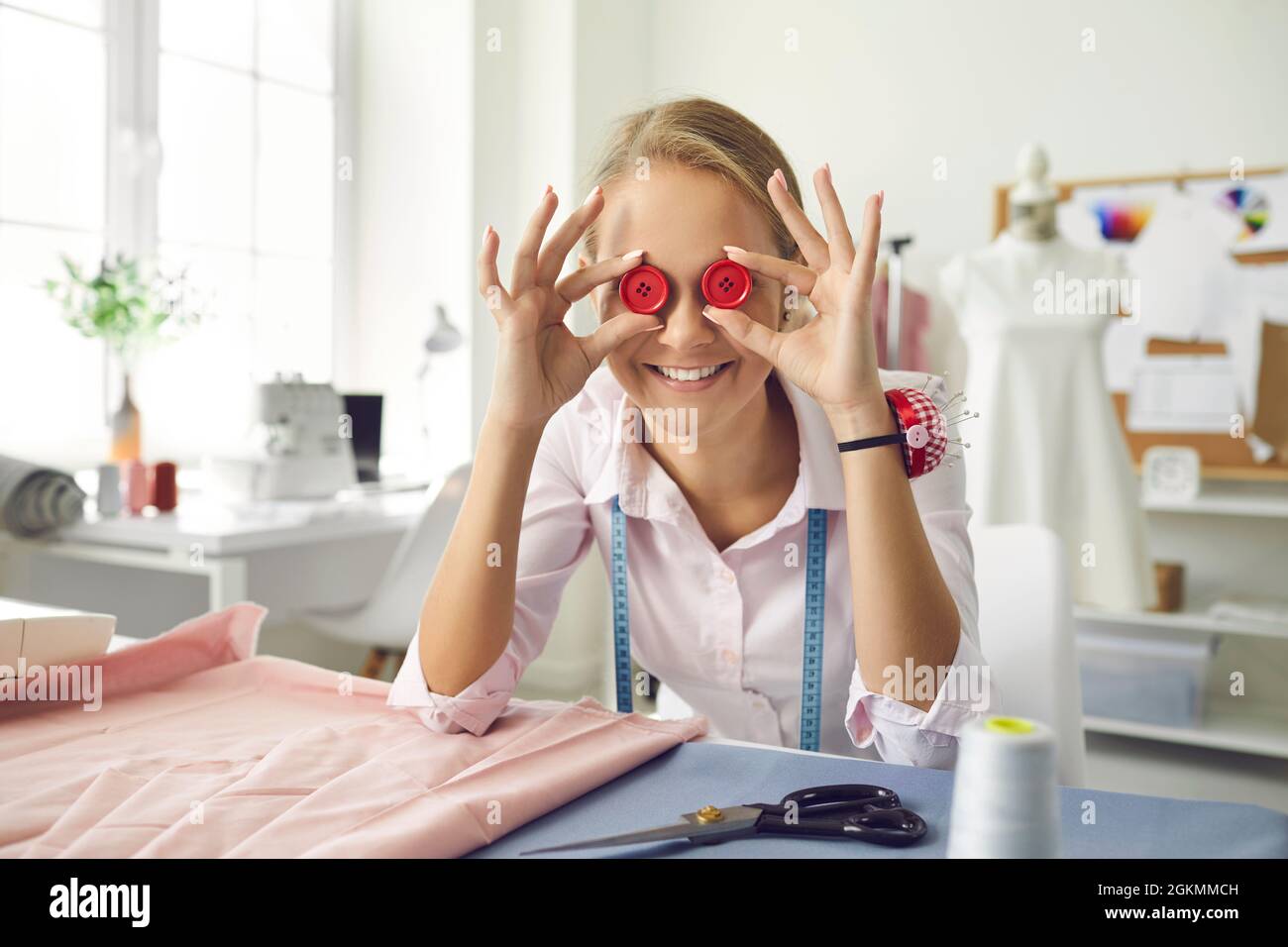 Funny portrait of happy dressmaker smiling and covering her eyes with ...