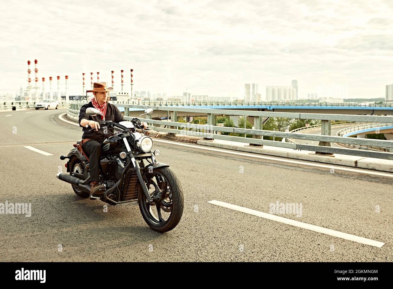 young man riding big bike ,motorcycle on city road against urban and ...