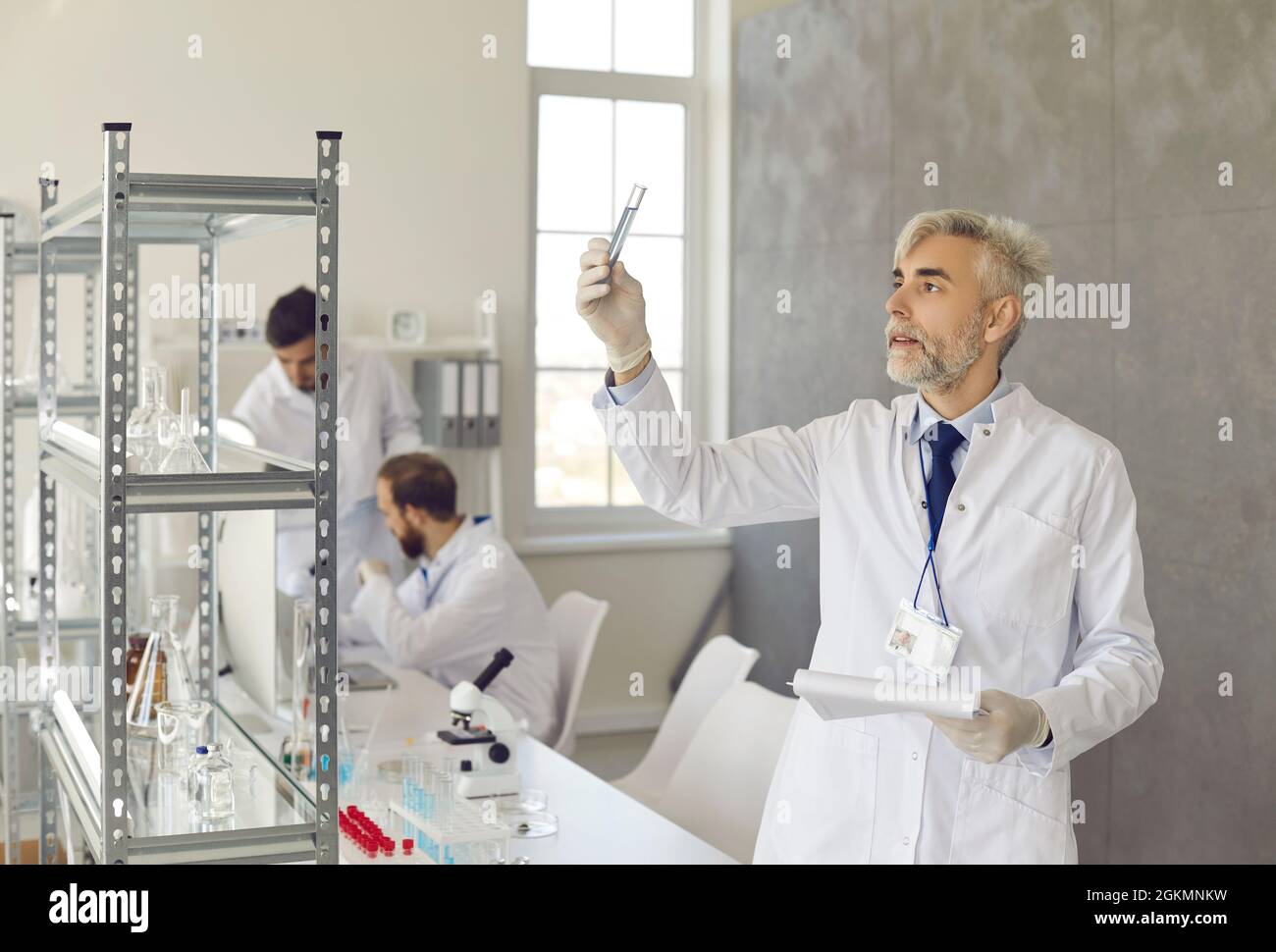 Serious senior male scientist working with chemical samples in a modern ...