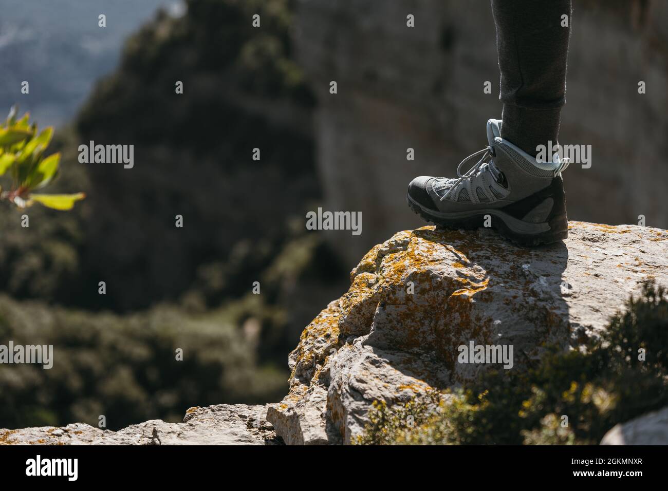 Hiking shoe stepping on a small rock with blurred landscape background ...