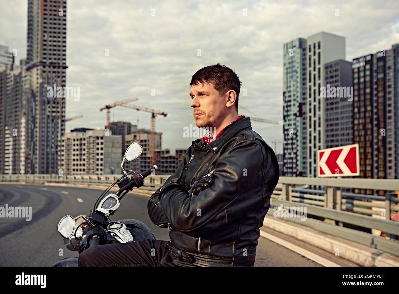 young man riding big bike ,motorcycle on city road against urban and ...
