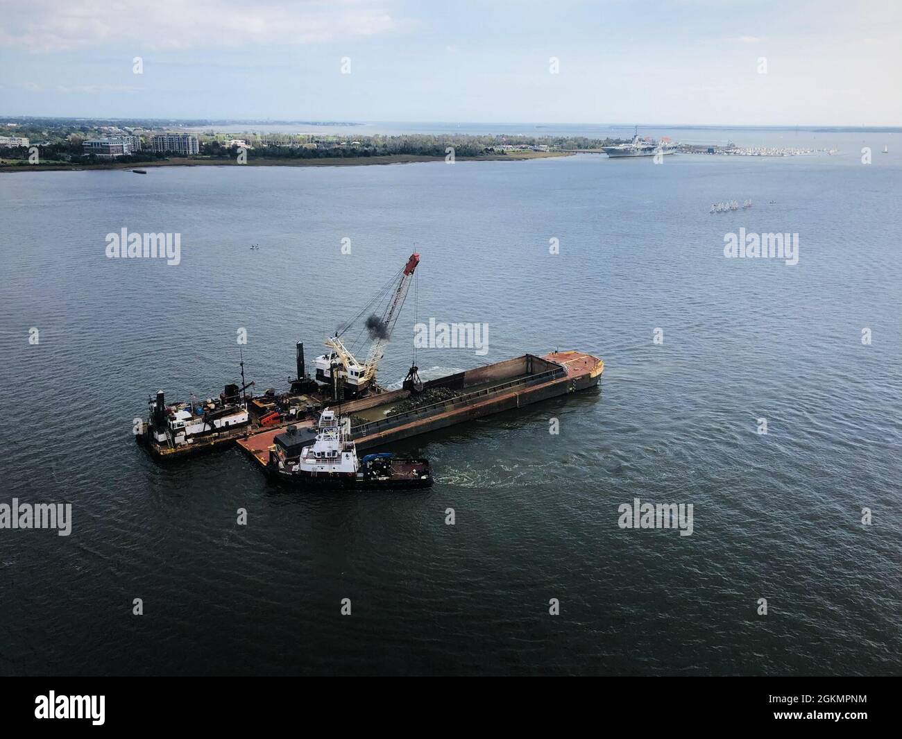 A mechanical dredge moves dredged material from Charleston Harbor to a ...