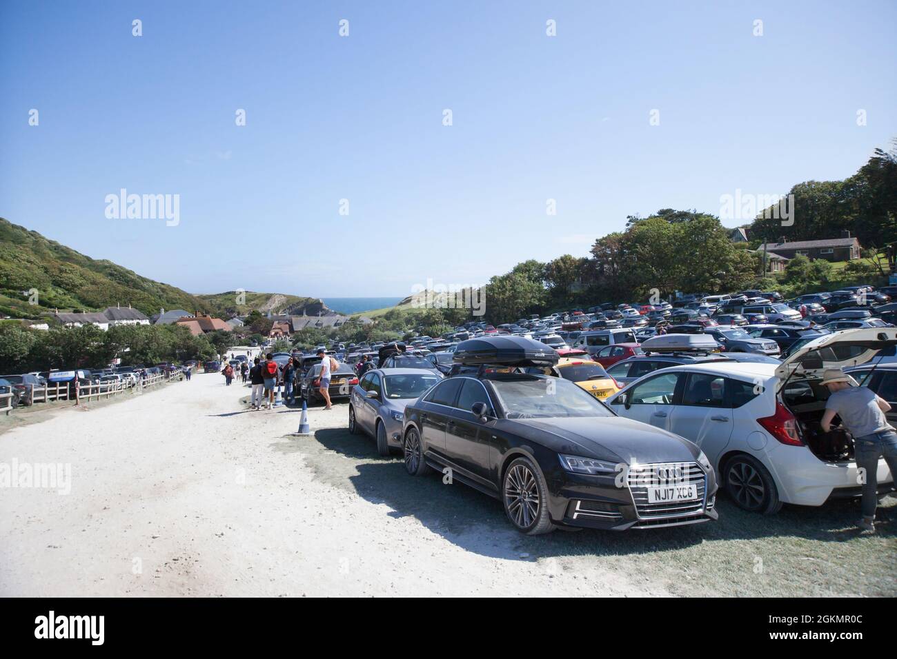 A full car park at Lulworth Cove, Dorset in the UK during the summer of ...
