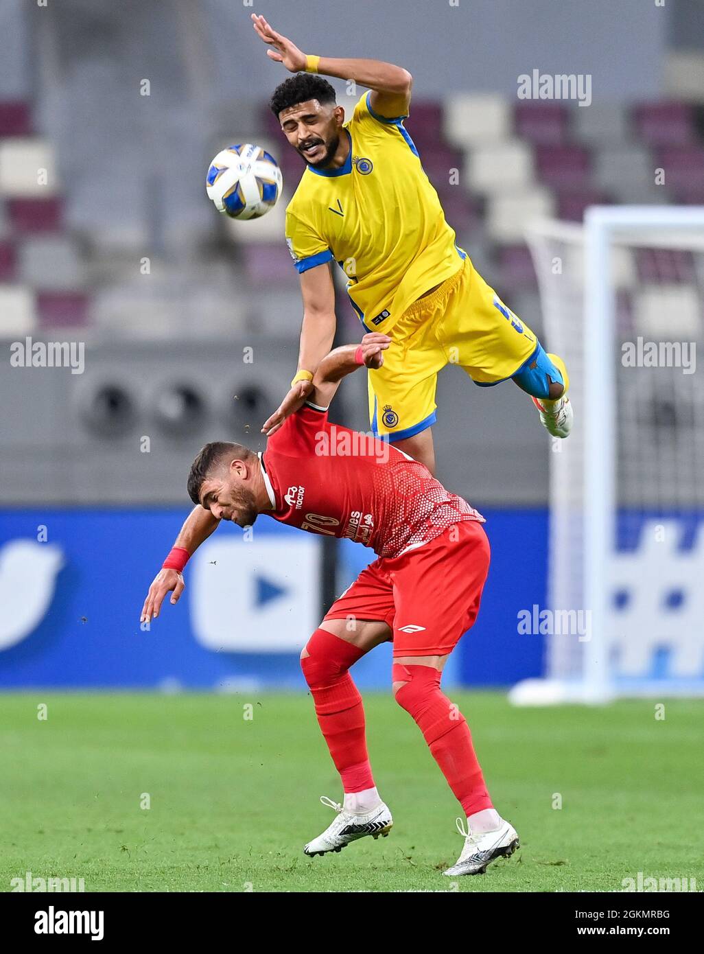 Doha, Qatar. 14th Sep, 2021. Abdulelah Alamri (top) of Al Nassr vies ...